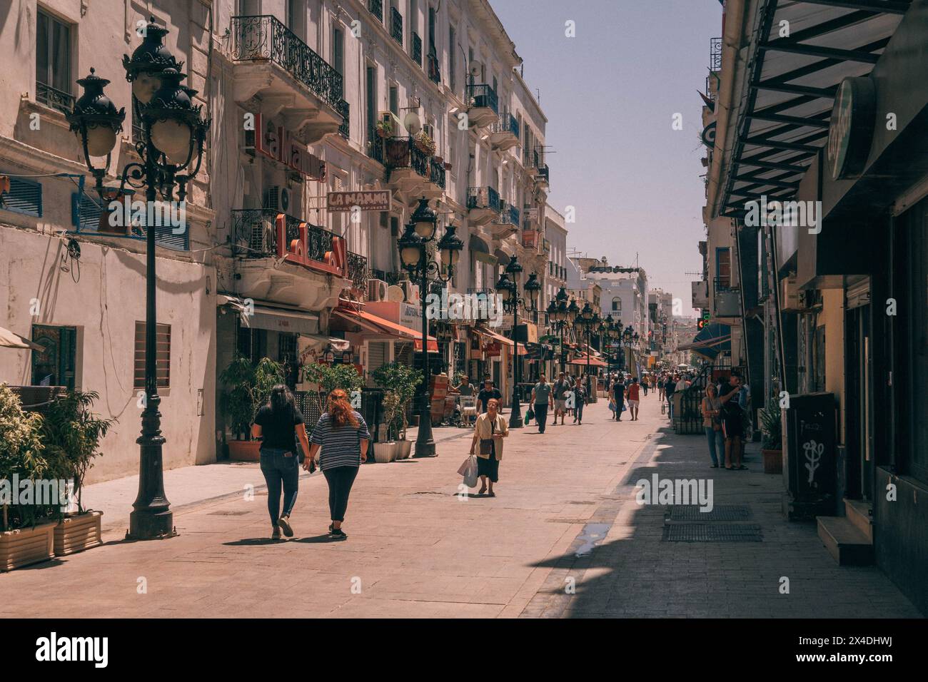 The people walk down the scenic promenade with colonial-style buildings ...