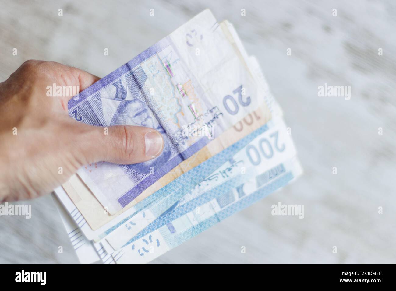 Hand holding Moroccan banknotes, dirham official currency of Morocco ...