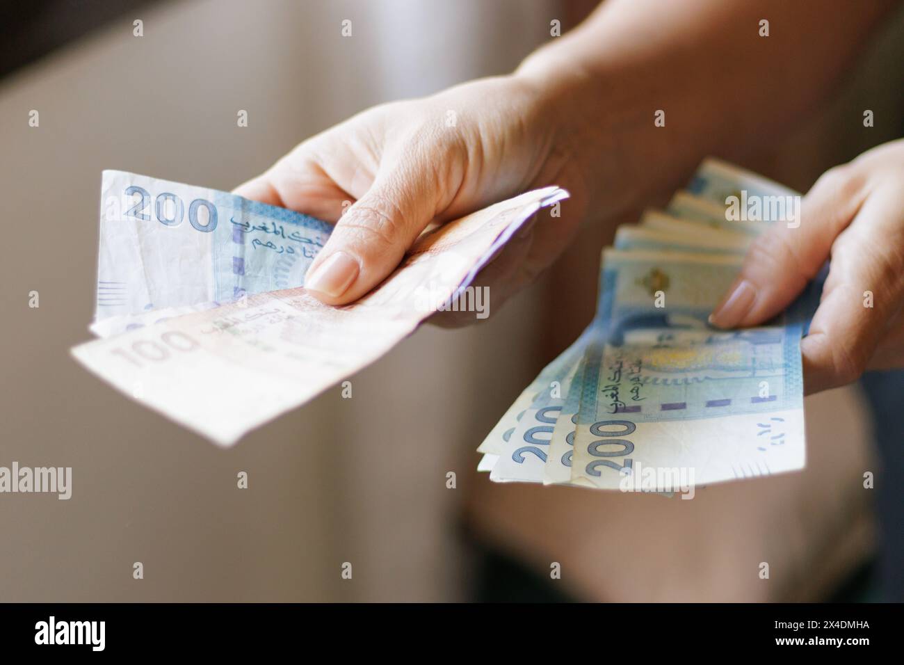 Hand holding Moroccan banknotes, dirham official currency of Morocco ...