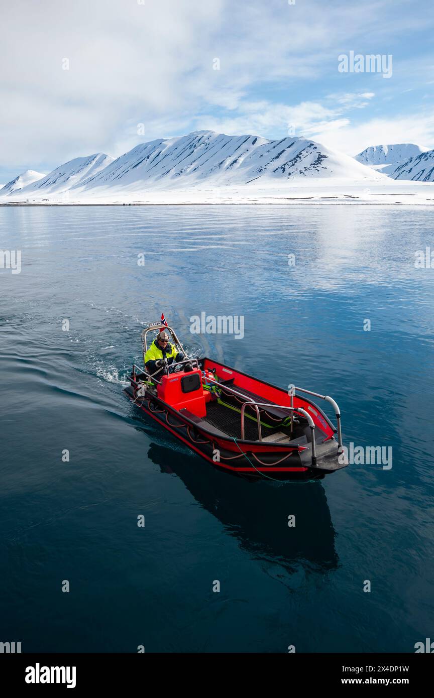 An inflatable raft cruises Mushamna Bay rimmed with mountains ...