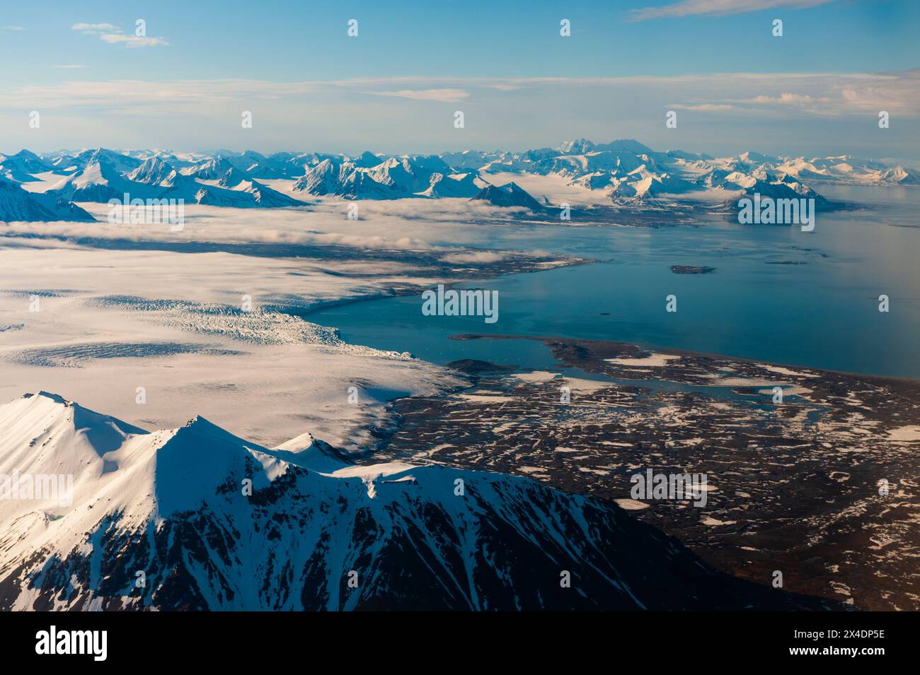 Sunlight reflects off ice covered mountains and the sea at Spitsbergen Island, Svalbard, Norway ...