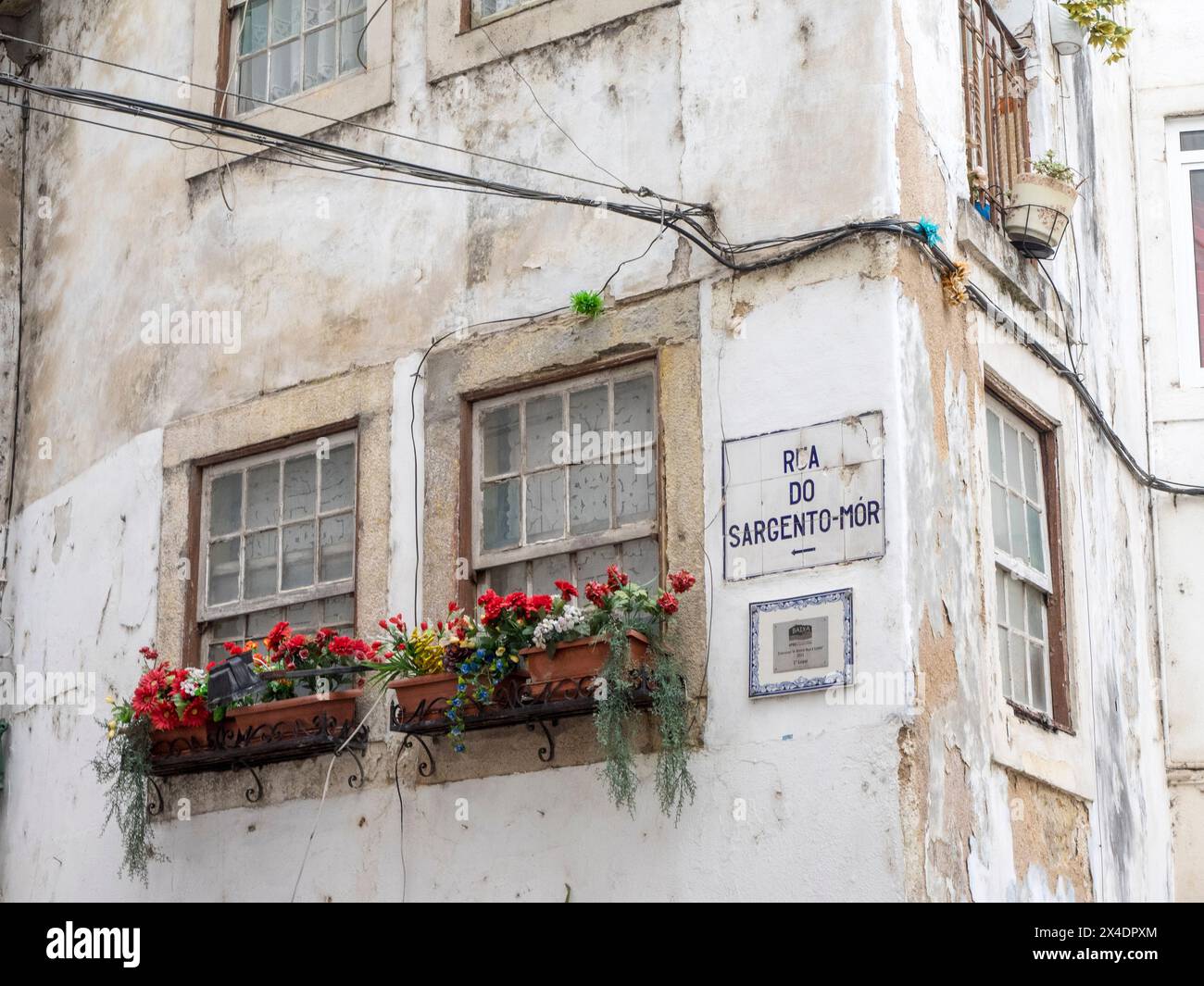 Flower pots hanging from the window of a home in the historic district ...