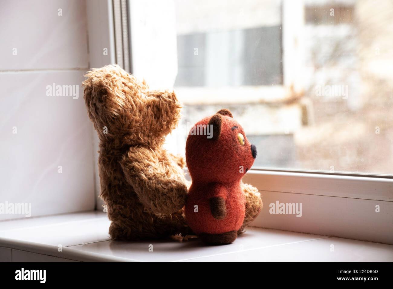 Children's soft toys sit on the window and look out the window, toys ...