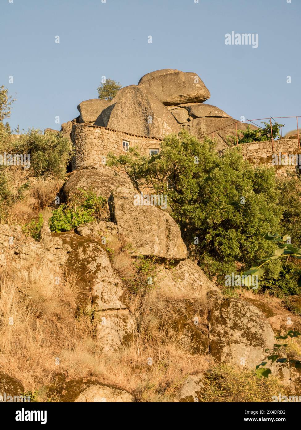 Stone house built under a large boulder in the medieval historic ...