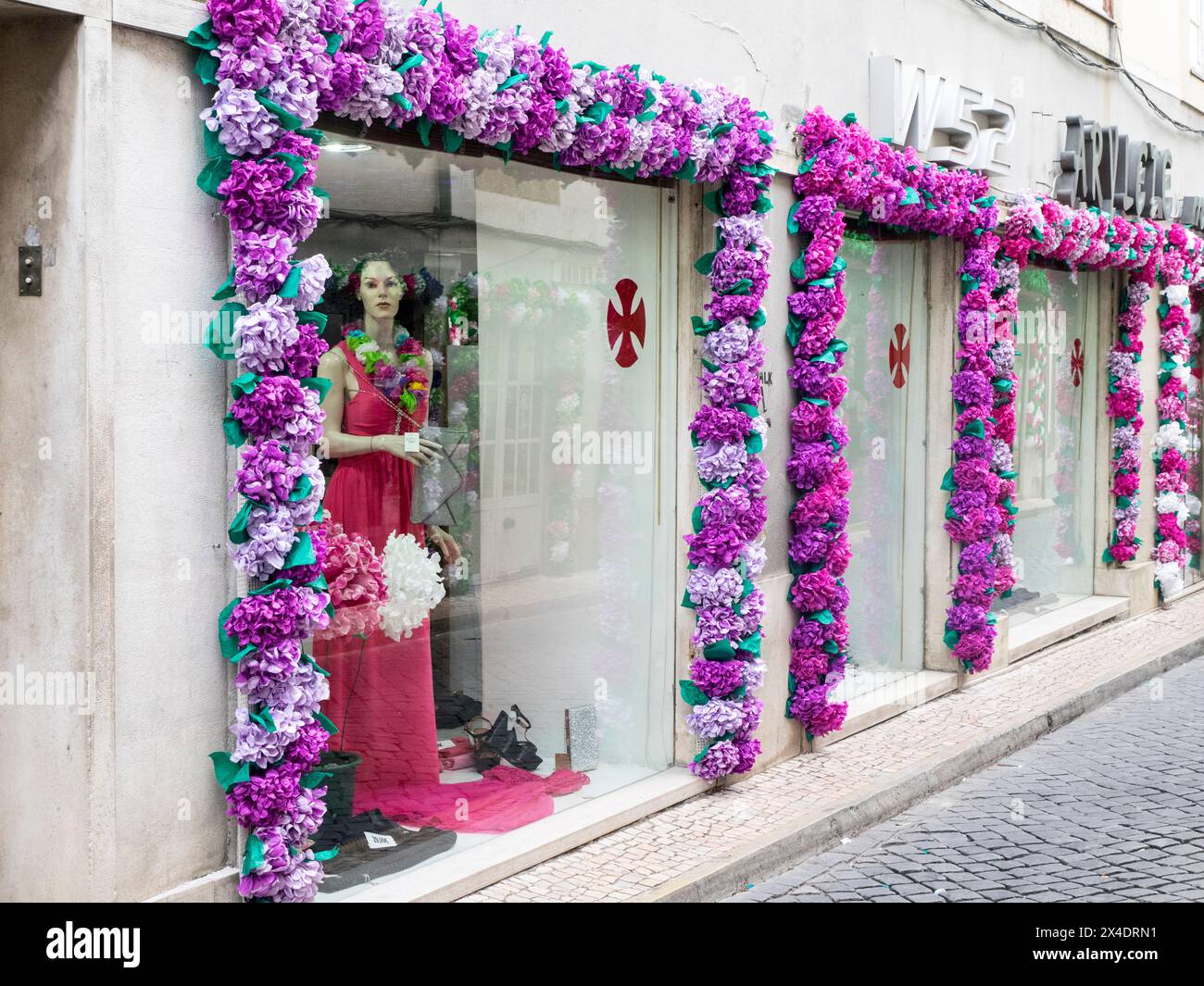 Paper flowers decorating shop windows during the Festa dos Tabuleiros ...