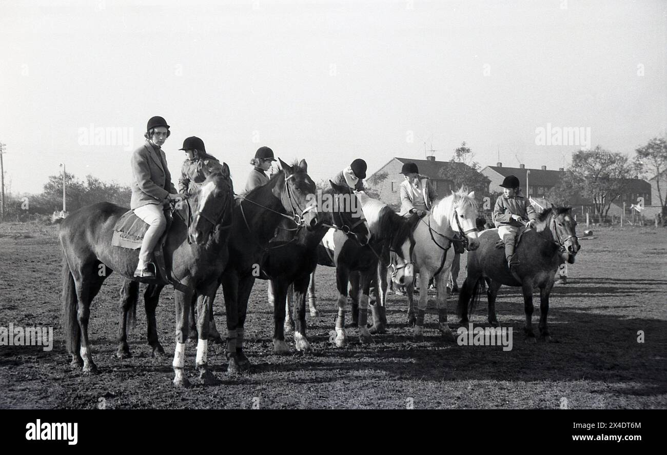1960s, historical, outside in a field at a riding school, a group of ...