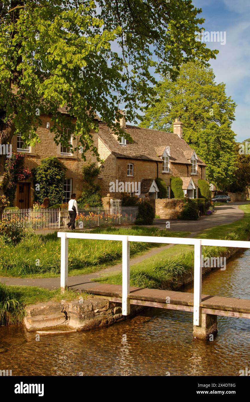 Stone cottages line the River Eye in the pretty Cotswold village of ...