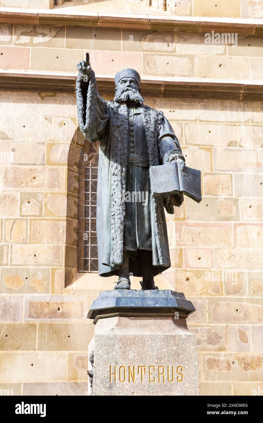 Romania, Brasov. Johannes Honterus statue. Pointing at German school ...