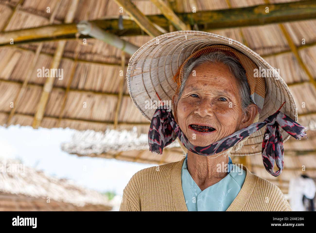 Vietnam, Hoi An, Aged woman with red betel nut stains in her mouth ...
