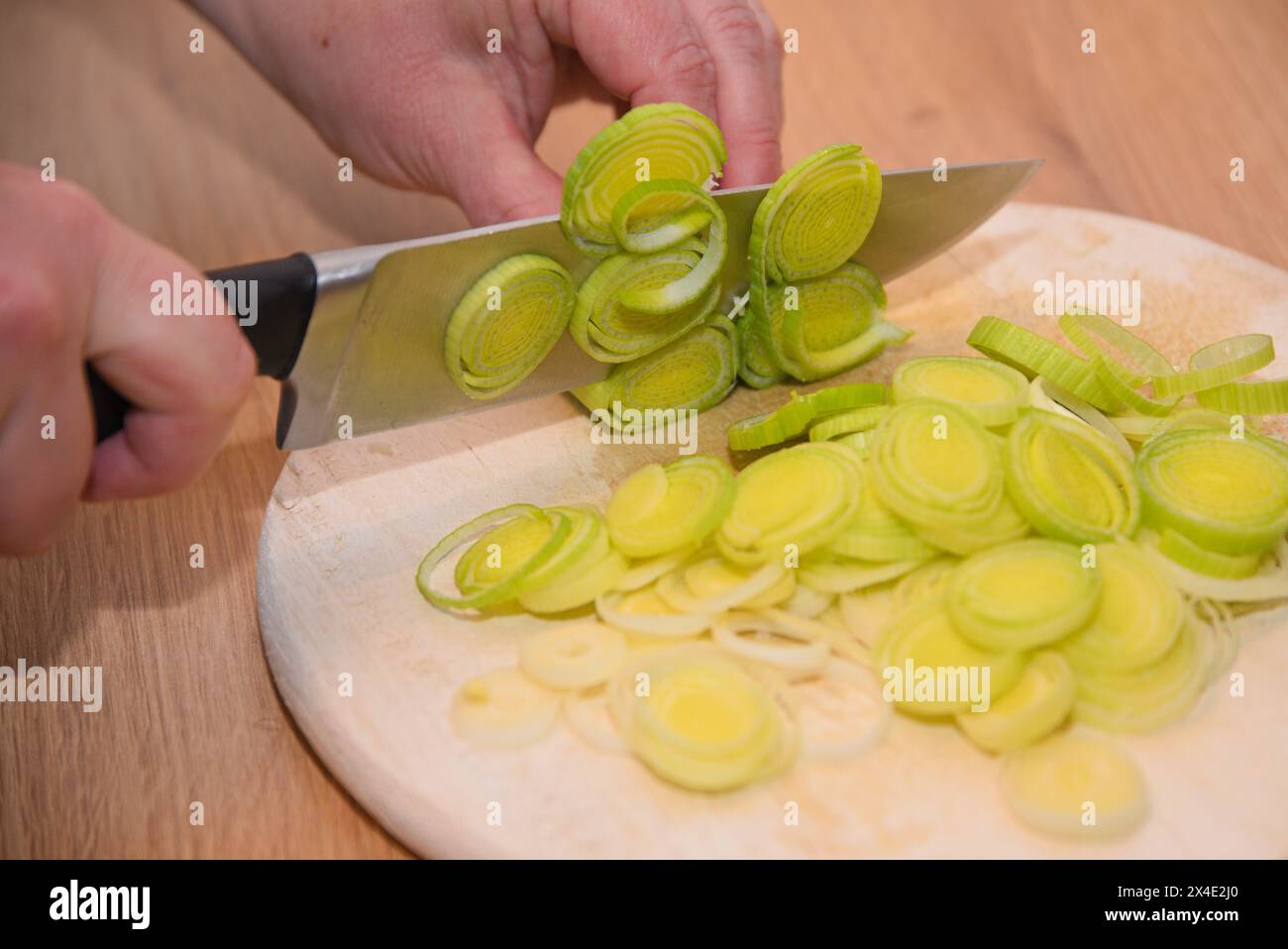 Person Cutting Leeks In The Kitchen - Leek Freshly Cut Stock Photo - Alamy