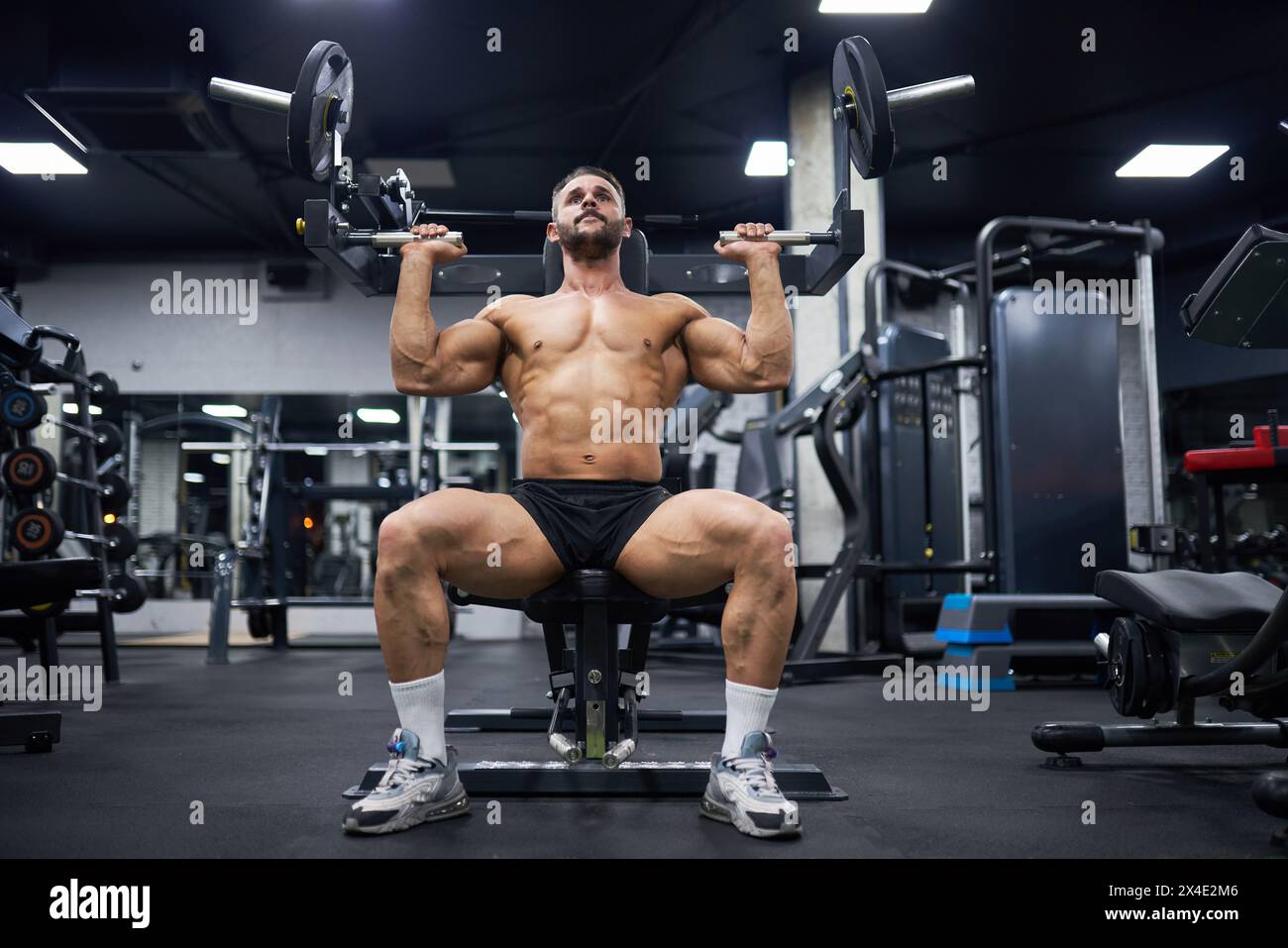 Attractive bearded man doing exercise with training apparatus in gym ...
