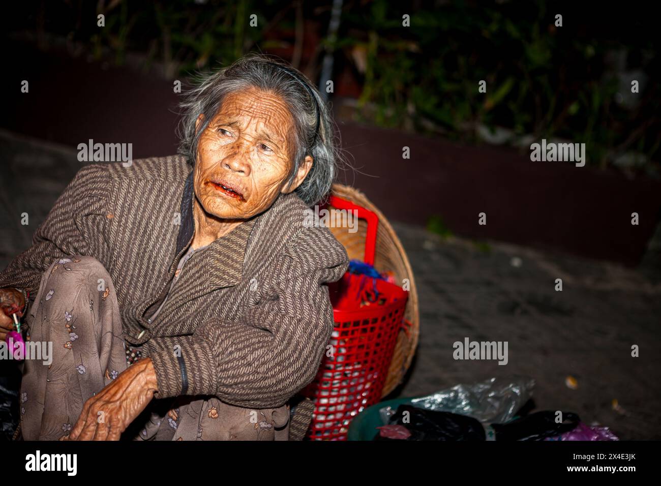Vietnam, Hoi An, Aged woman with red betel nut stains in her mouth ...