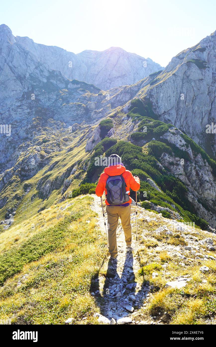 Photographed from the back of a man walking along a mountain path in a ...