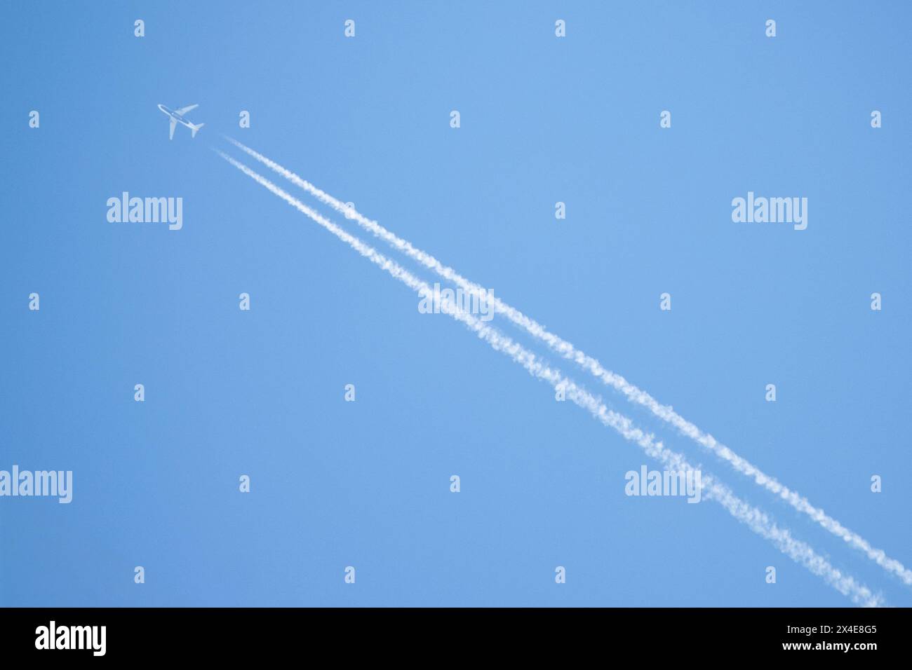 Contrails from a twin engine passenger plane Stock Photo - Alamy