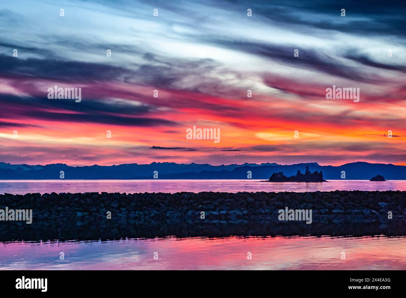 USA, Alaska, Tongass National Forest. Sunset reflects on clouds and ...