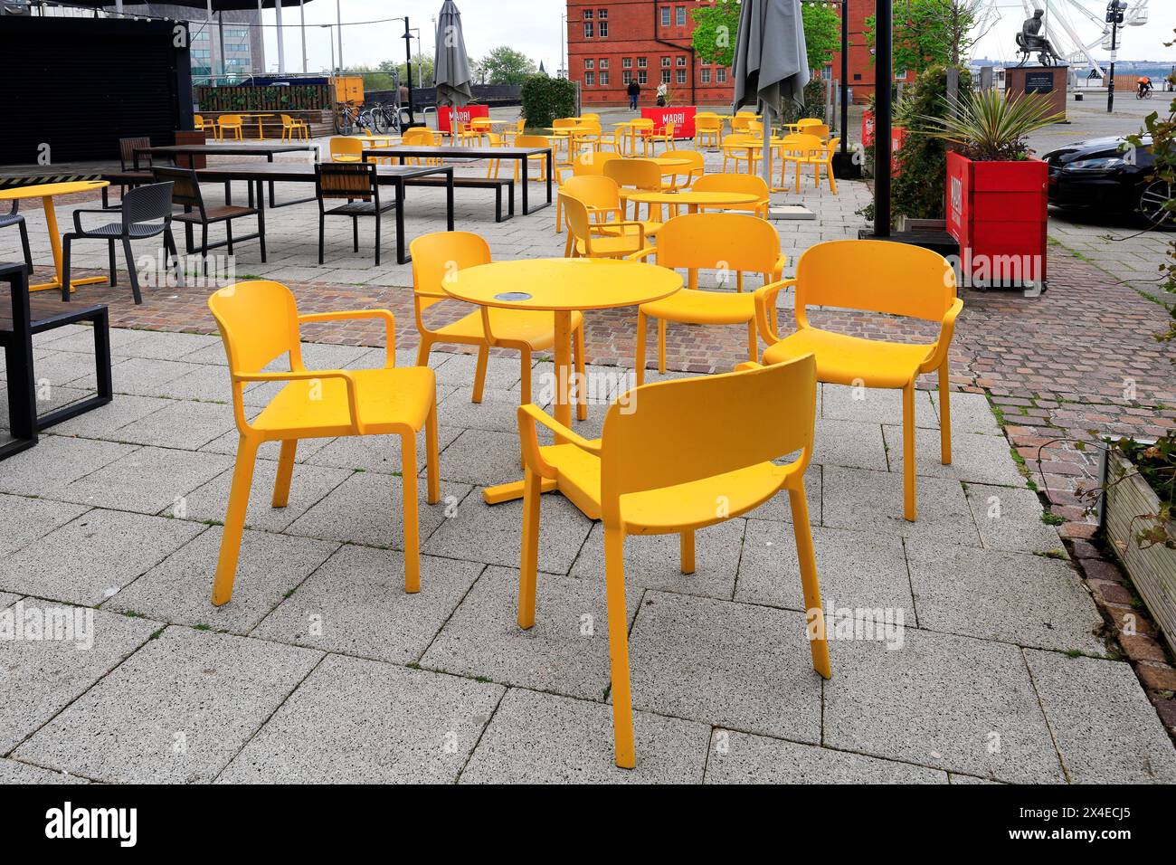 Inviting bright yellow tables and chairs at an outdoor seating area ...