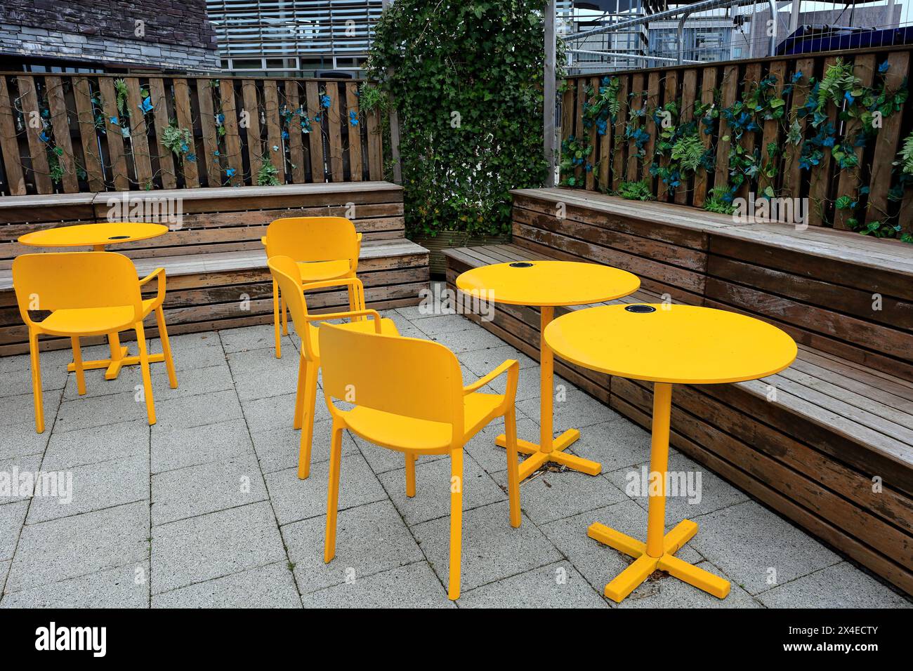 Inviting bright yellow tables and chairs at an outdoor seating area ...