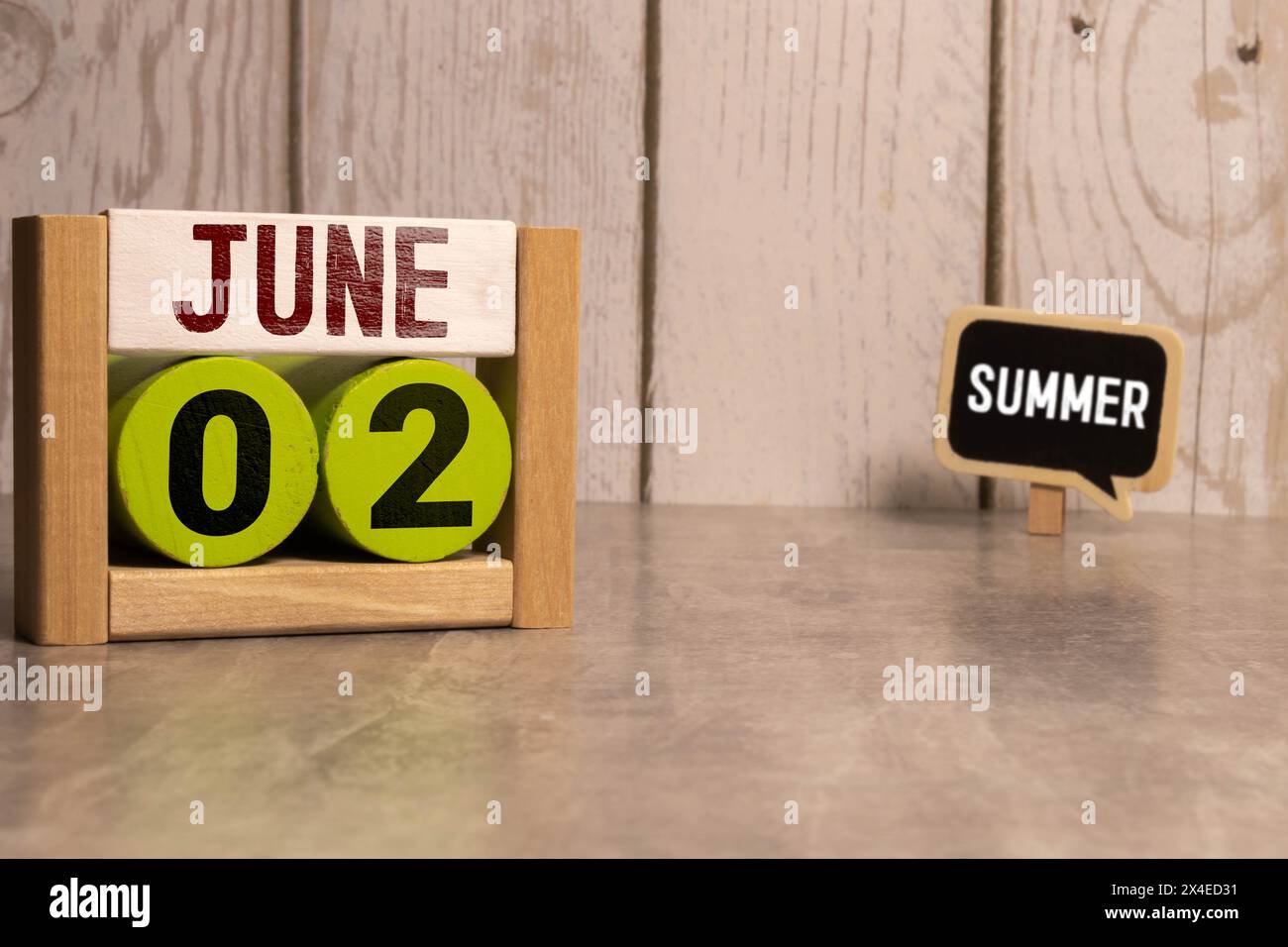 Cube shape calendar for June 02 on wooden surface with empty space for ...