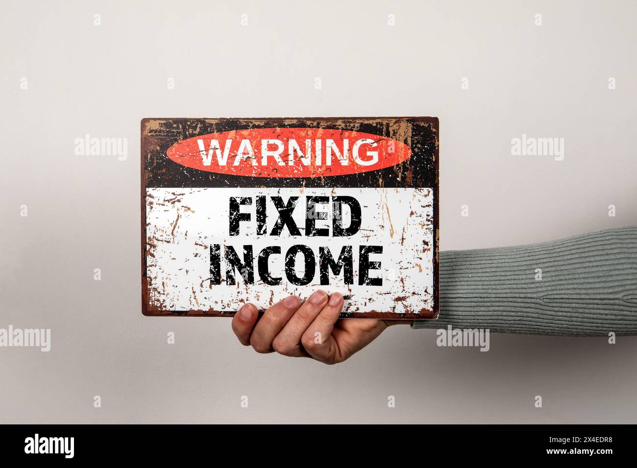 Fixed Income. Warning sign with text in hand Stock Photo - Alamy