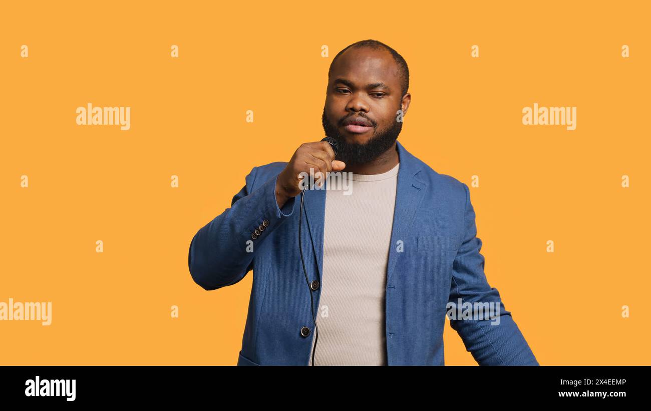 Smiling singer holding microphone, performing tunes during concert ...