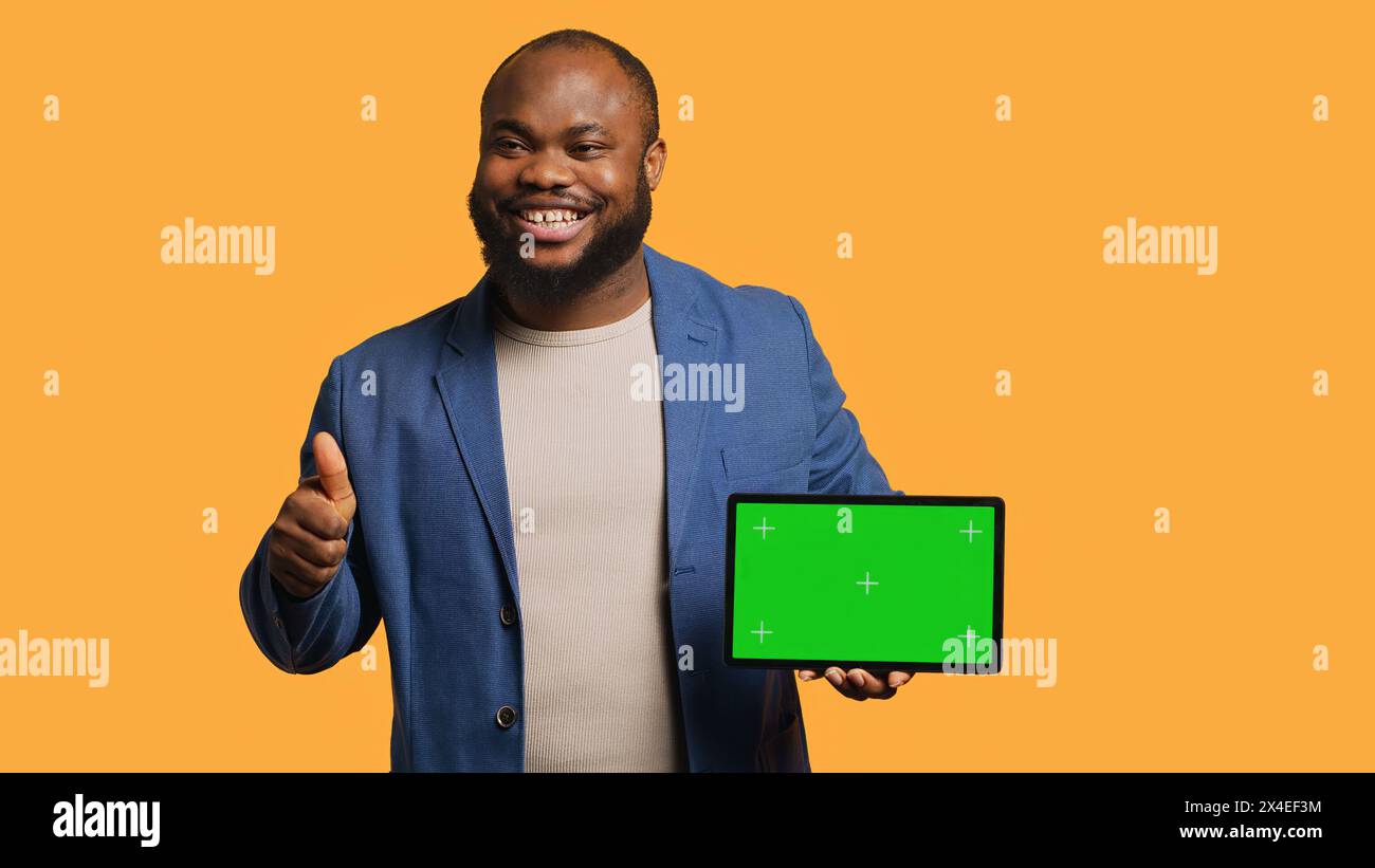 Jolly man holding isolated screen tablet, doing recommendation ...