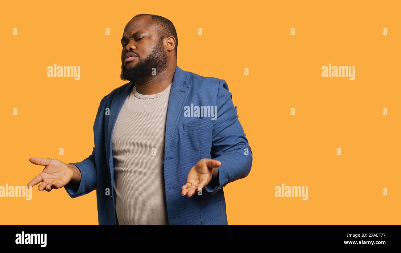 Uncaring man shrugs shoulders, showing indifference and apathy while ...