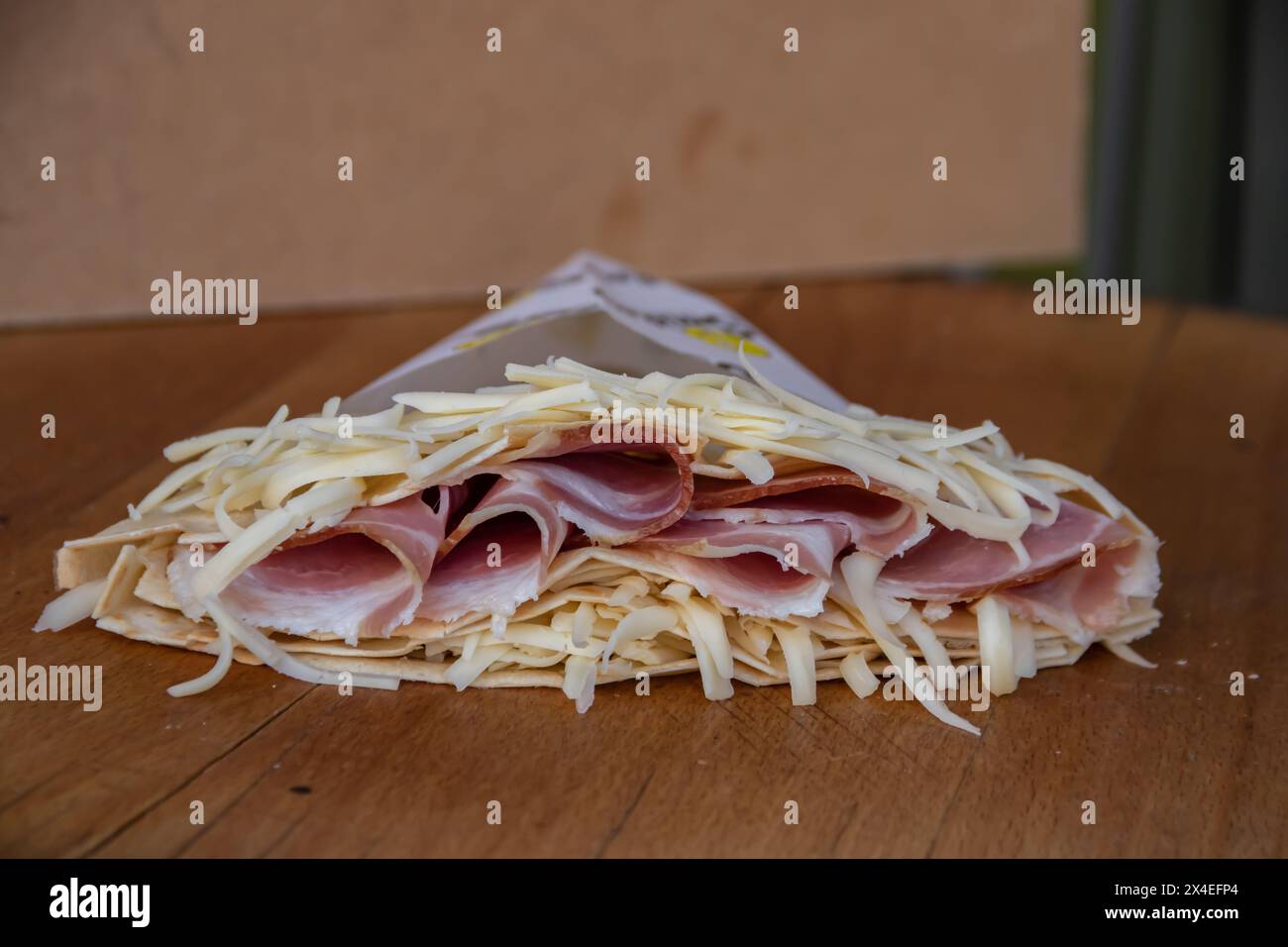 A savory pancake filled with ham and melted cheese offers a delightful ...