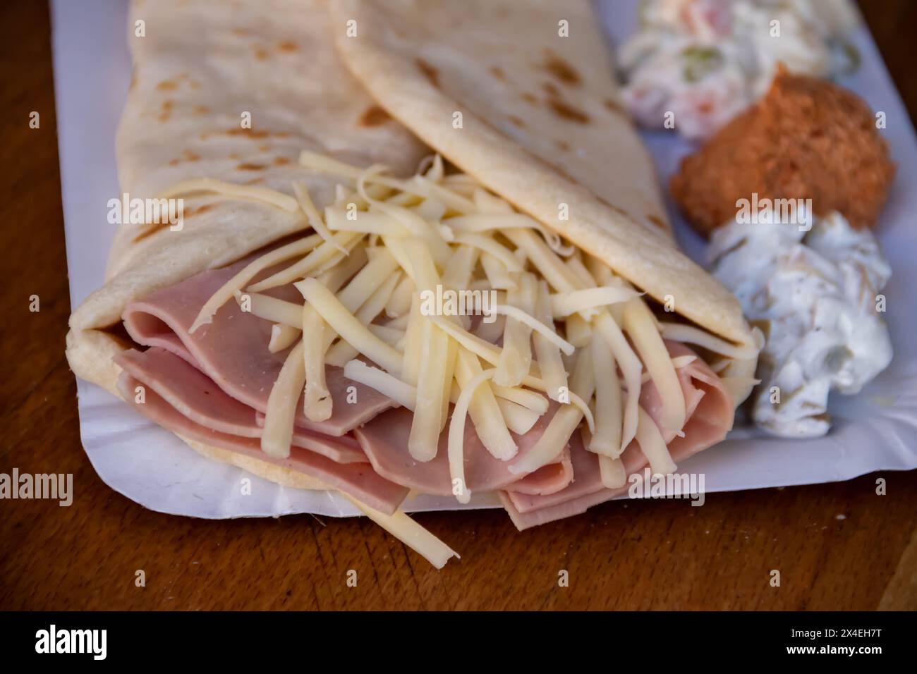A savory golden pancake filled with ham and melted cheese offers a ...