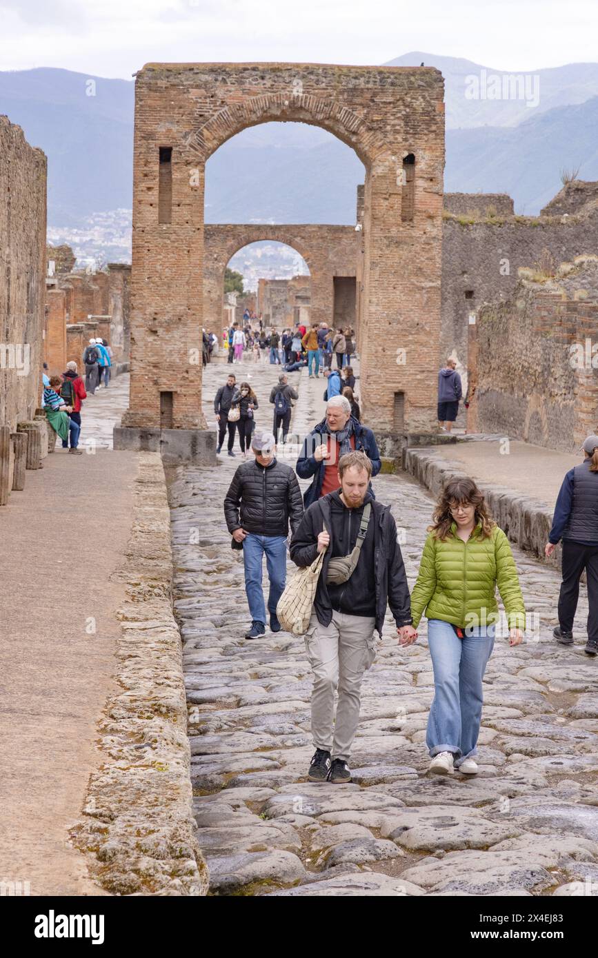 Visitors in Pompeii Italy; the Arch of Caligula and through it, the ...