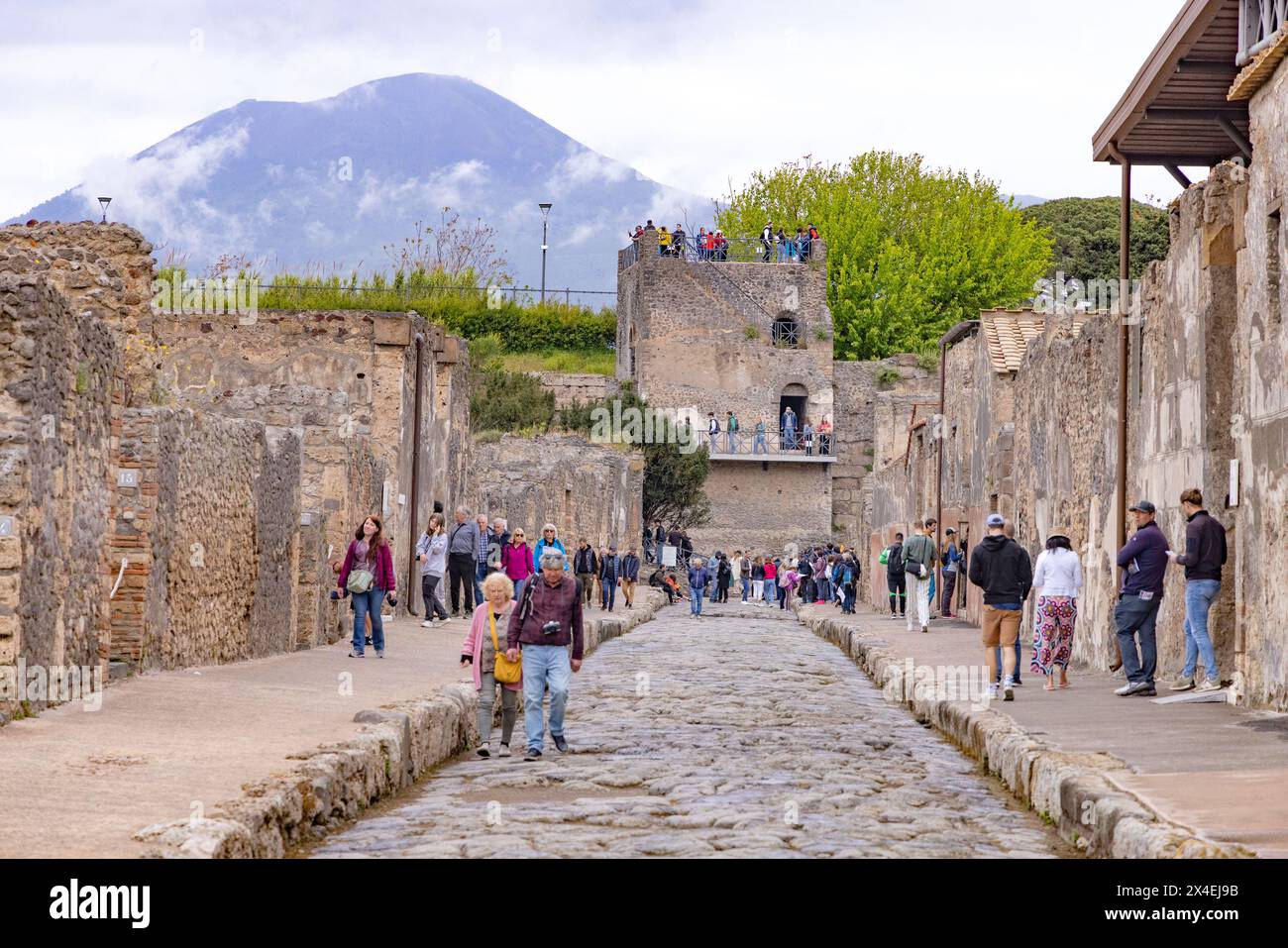 Pompeii Vesuvius; Tourists on the road with a watchtower in the wall of ...
