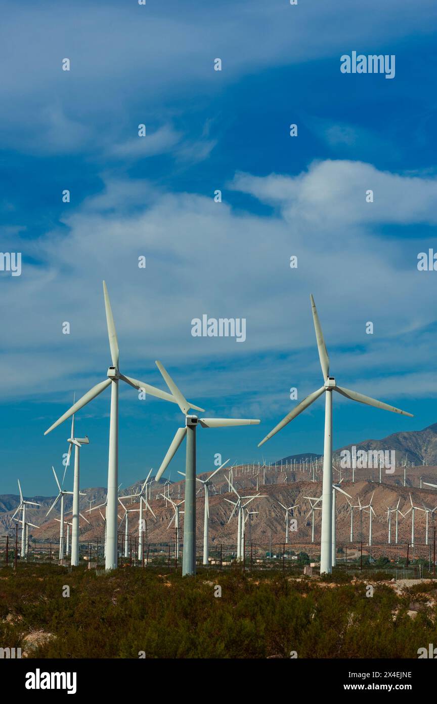 Rows of windmills in a landscape of low mountains, with clouds overhead ...