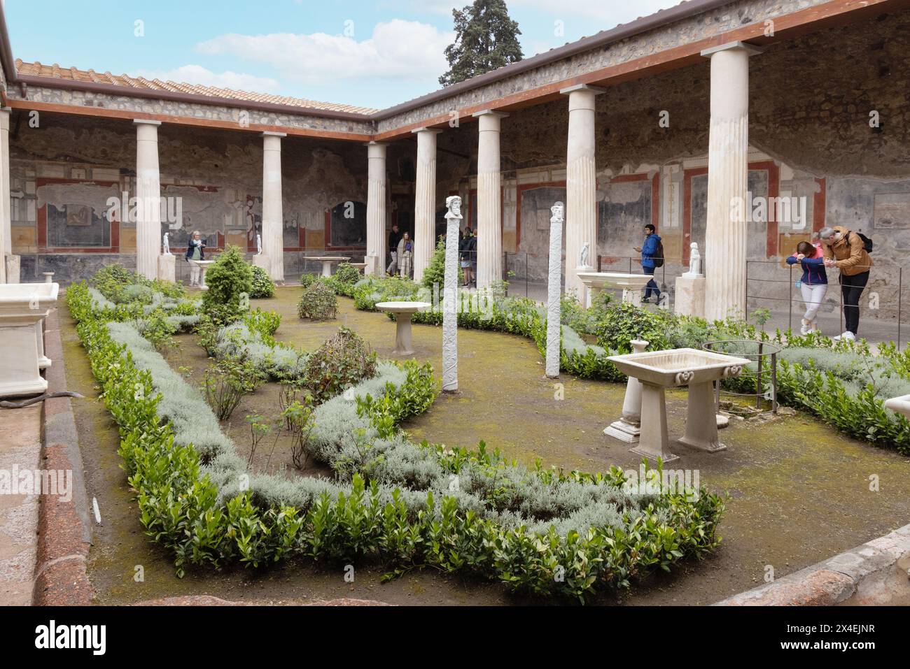 Pompeii villa; tourists in a Roman Garden preserved in the Casa Vettii ...