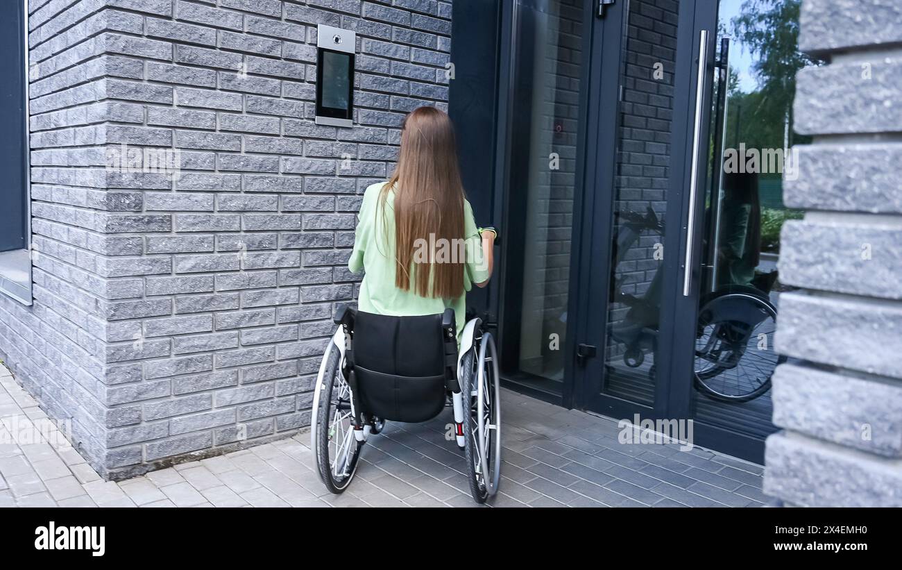 A woman in a wheelchair with an assistive device for manual control ...