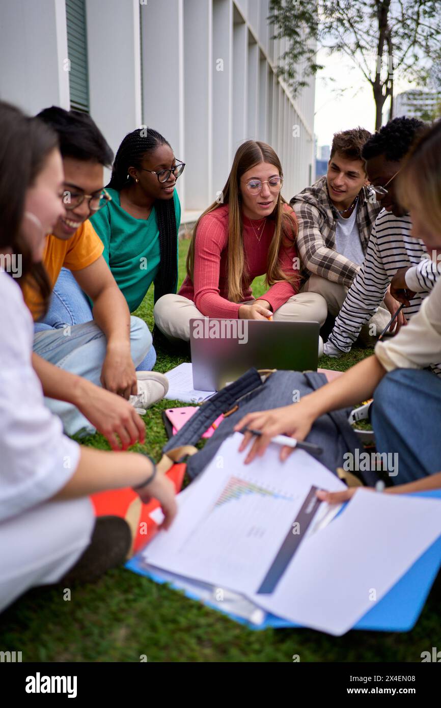 Group of young international students sitting on the grass outside the ...