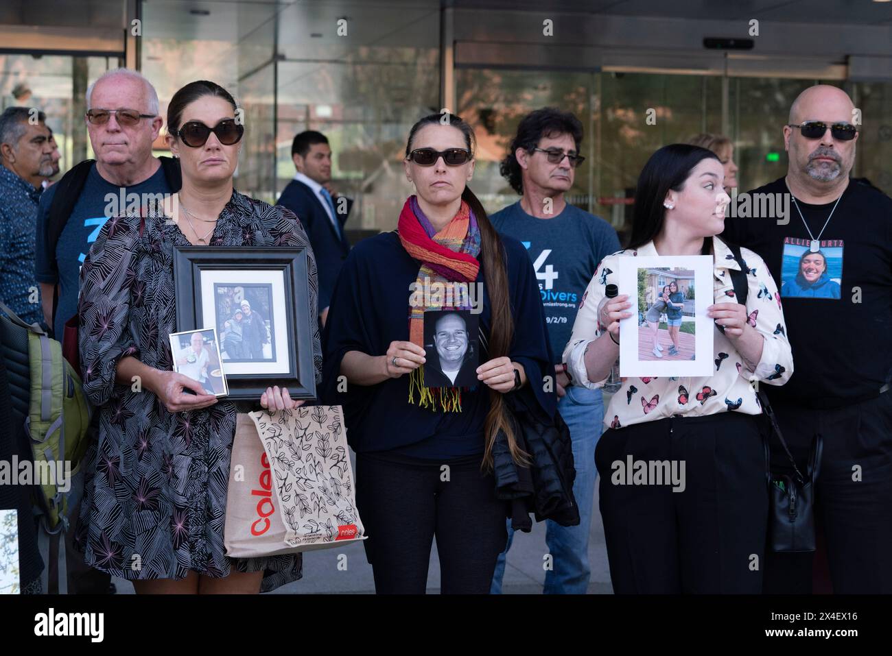Family members holding photos of their loved ones who died in the ...
