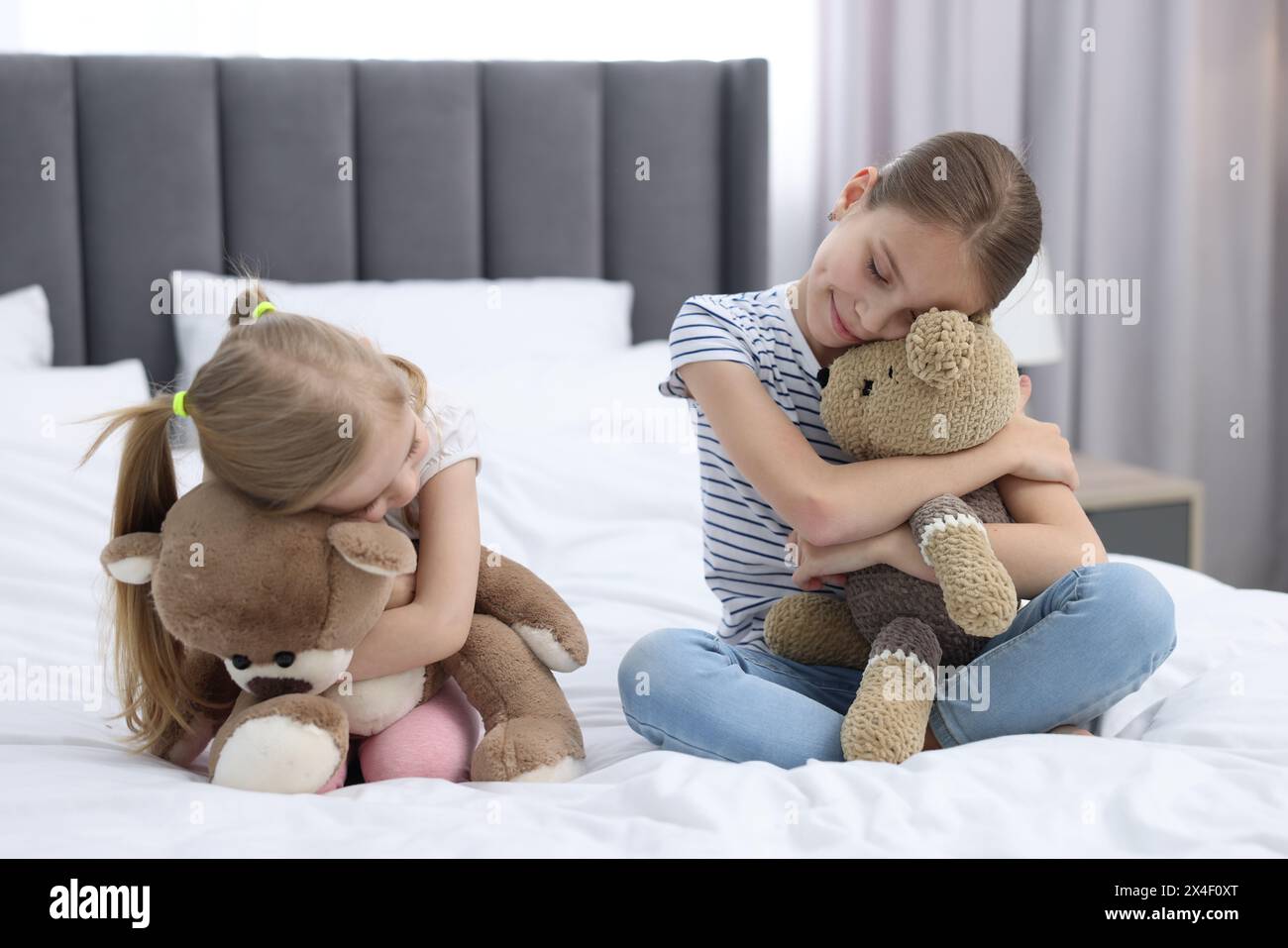 Cute little sisters with teddy bears on bed at home Stock Photo - Alamy