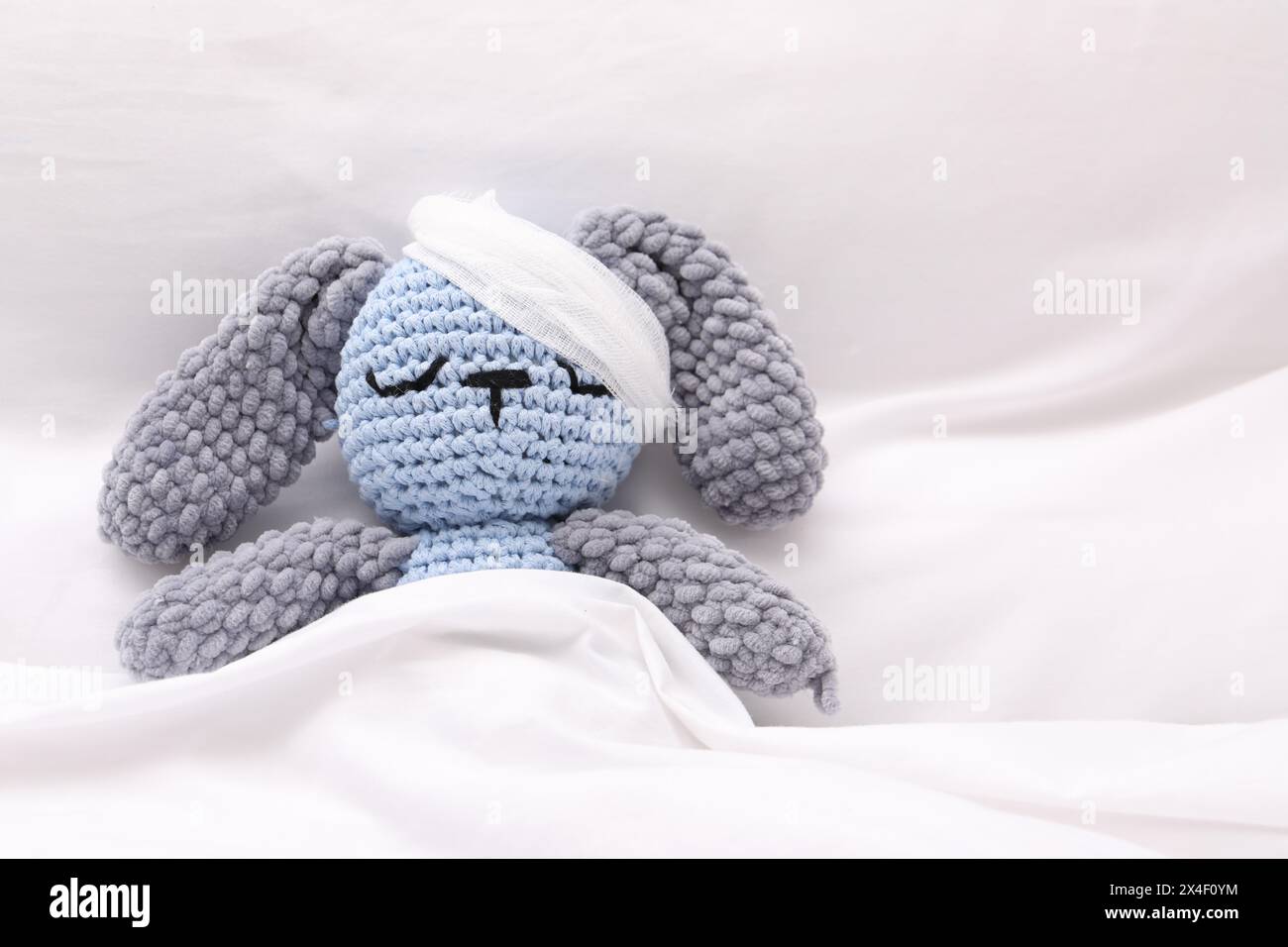 Toy cute bunny with bandage under blanket in bed Stock Photo - Alamy