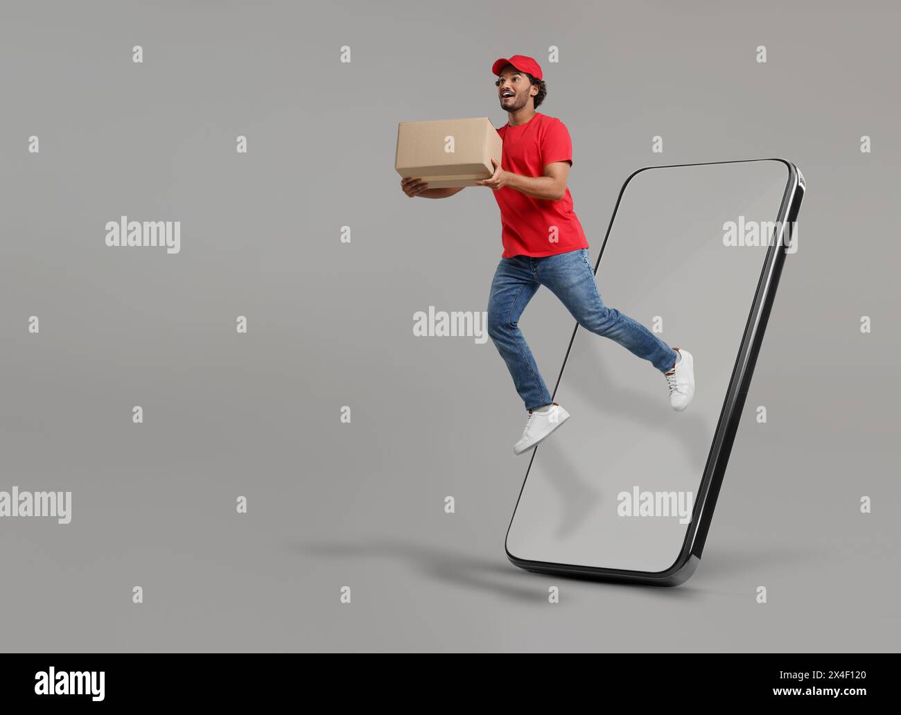 Courier with parcel flying out from huge smartphone on grey background ...