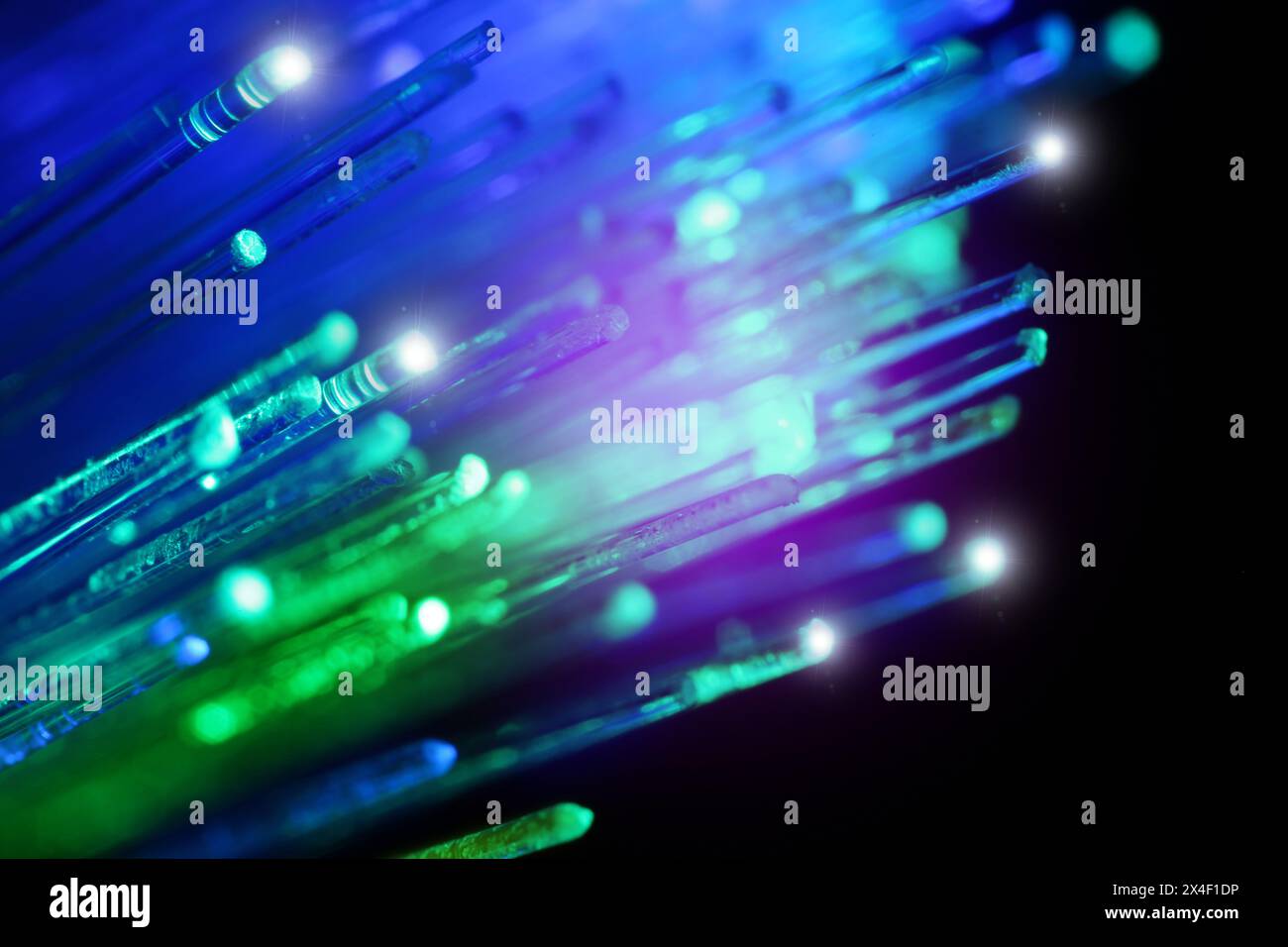 Optical fiber strands transmitting green and blue light on black ...