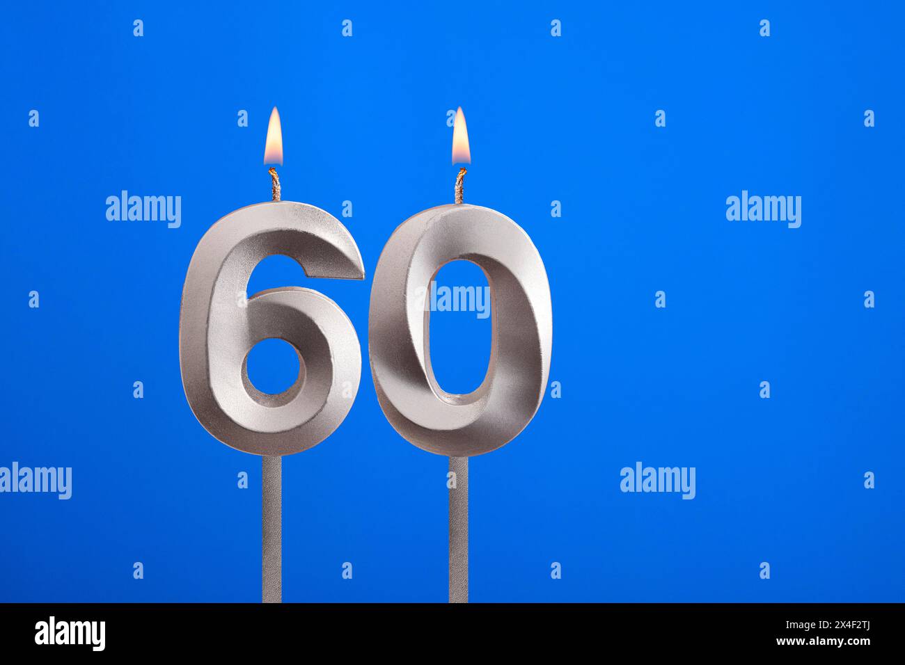 Birthday number 60 - Candle lit on blue background Stock Photo - Alamy