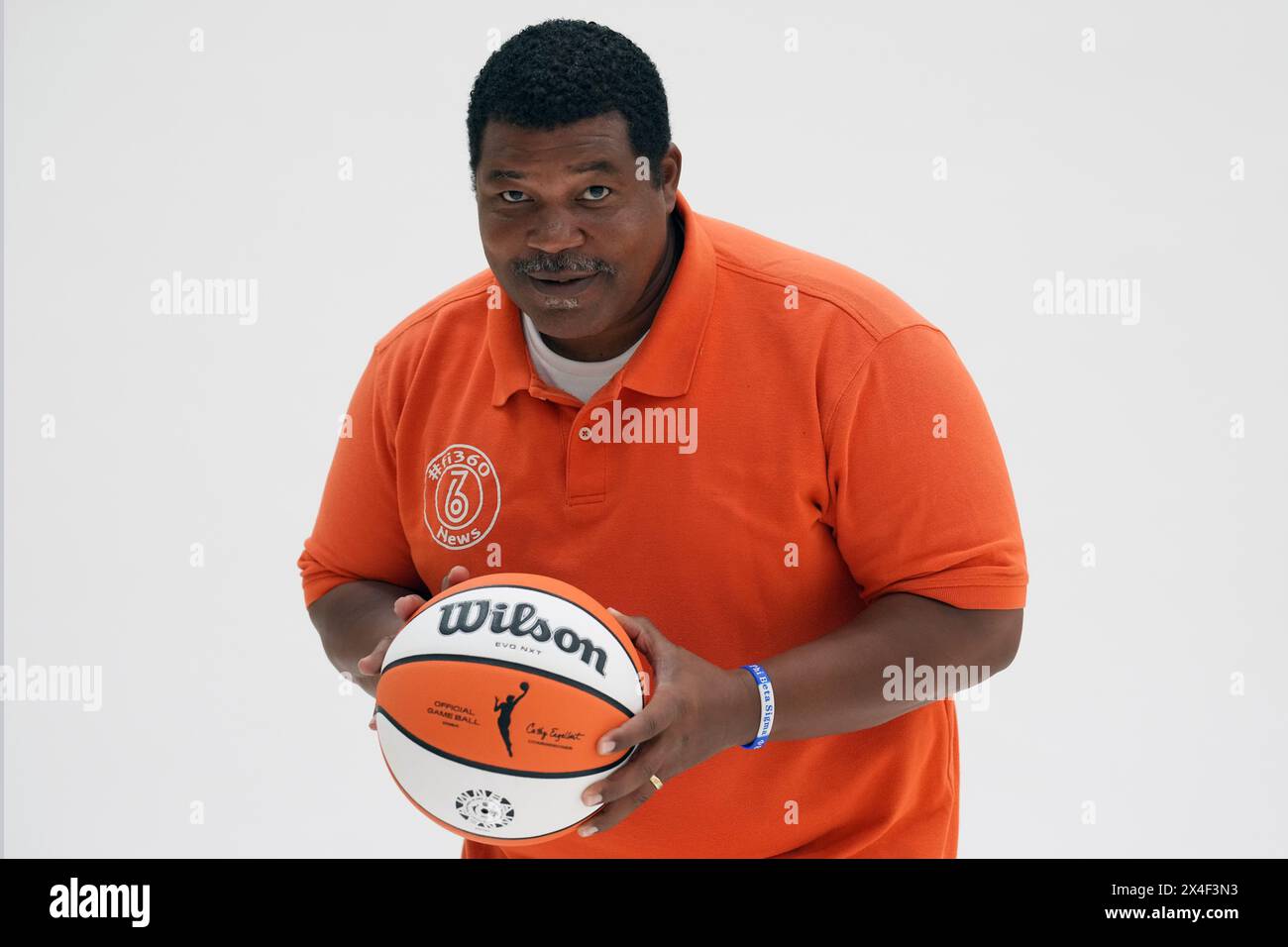 Jevone Moore aka Orange Man and Mr. Orange poses with a WNBA basketball ...