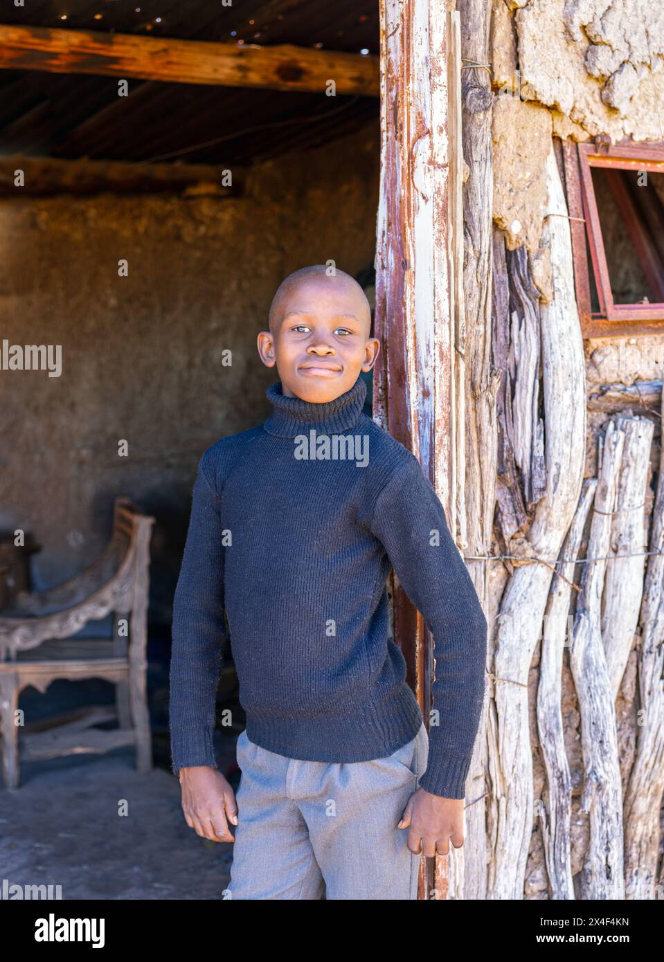 african village, single boy in front of the door, mud hut interior with ...