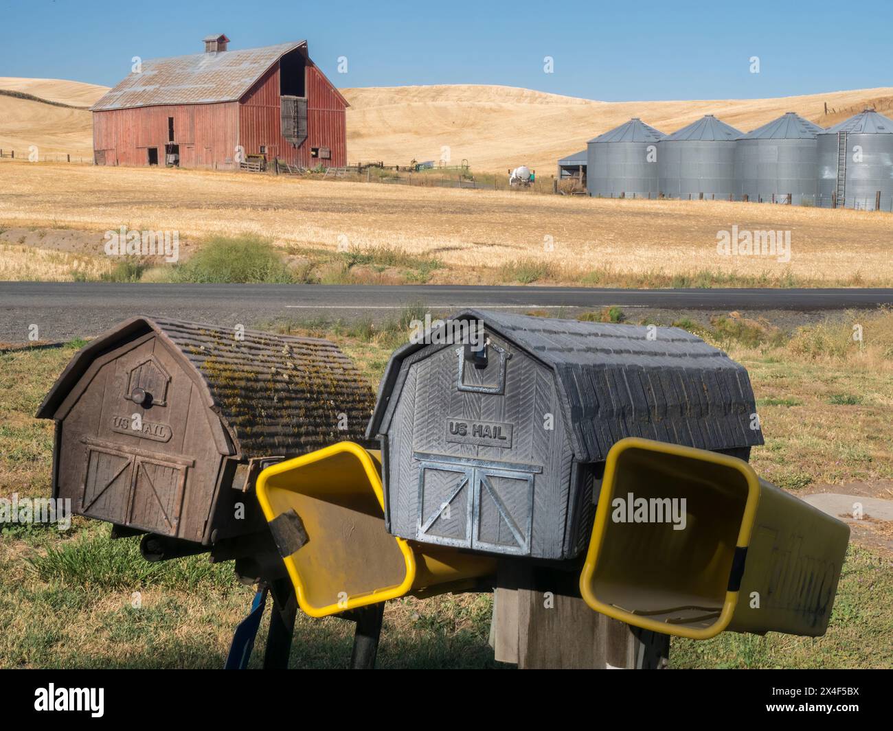 Red barn and grain bins with mailboxes in the foreground at harvest ...