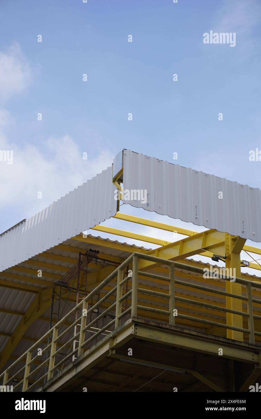 Yellow open building made of iron and asbestos roof with clear sky in ...