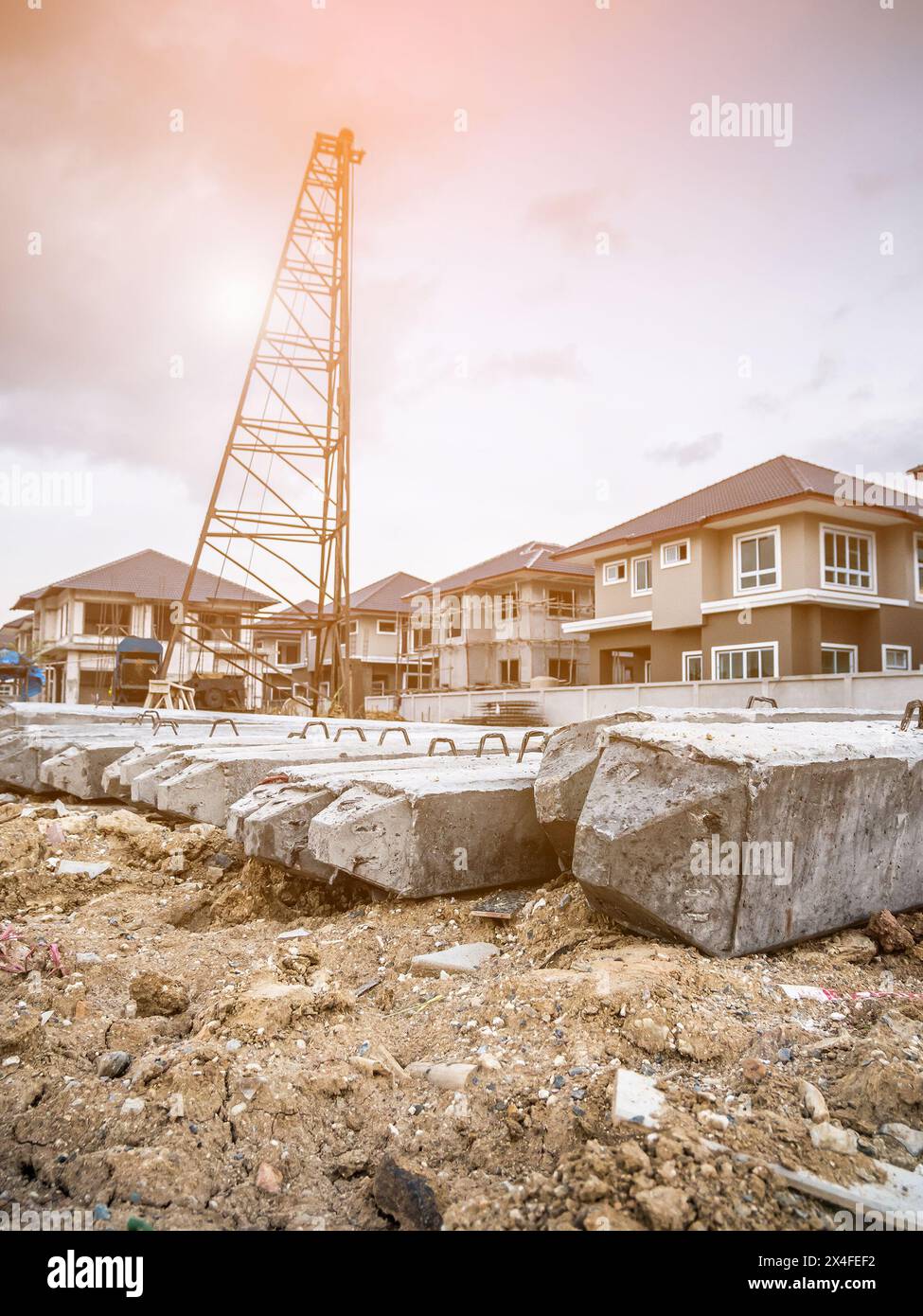 house building at construction site with pile driver and precast ...