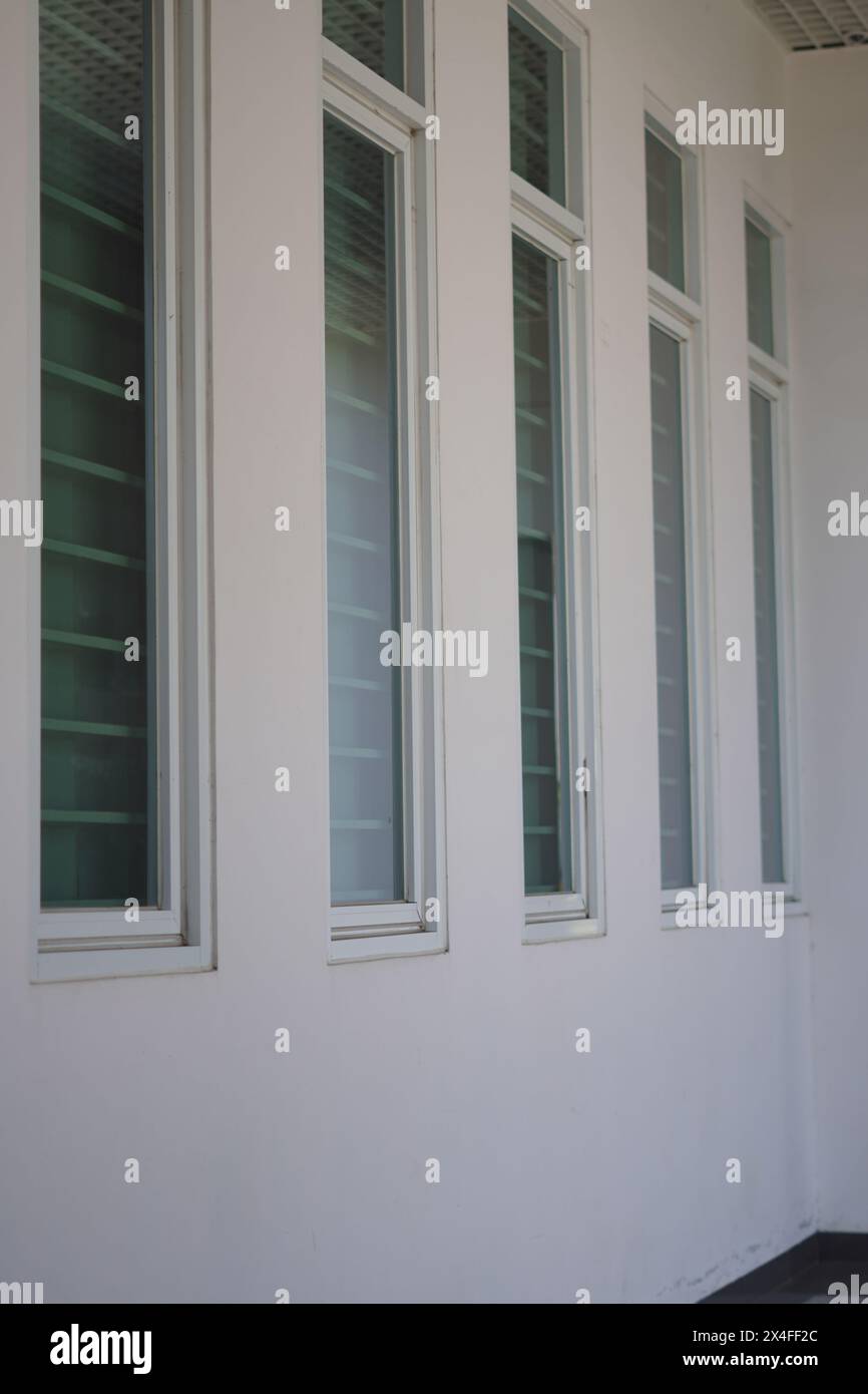 Windows with closed curtains line the white walls Stock Photo - Alamy