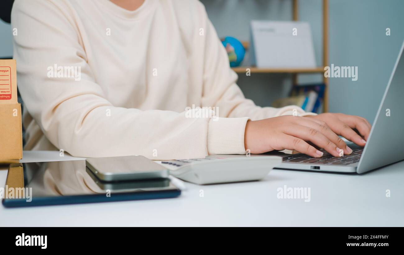 Woman runs an e-commerce business is checking orders from laptop, she ...