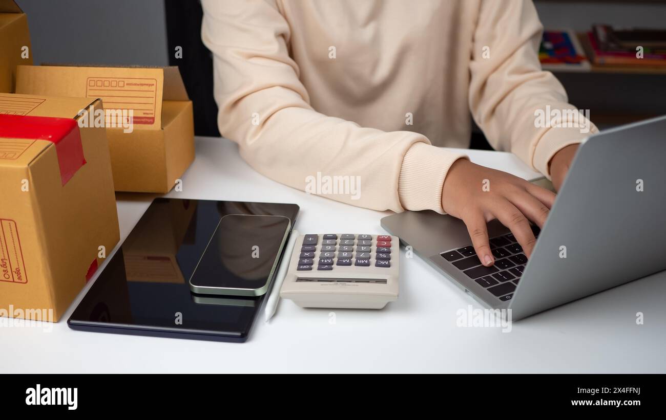 Woman runs an e-commerce business is checking orders from laptop, she ...
