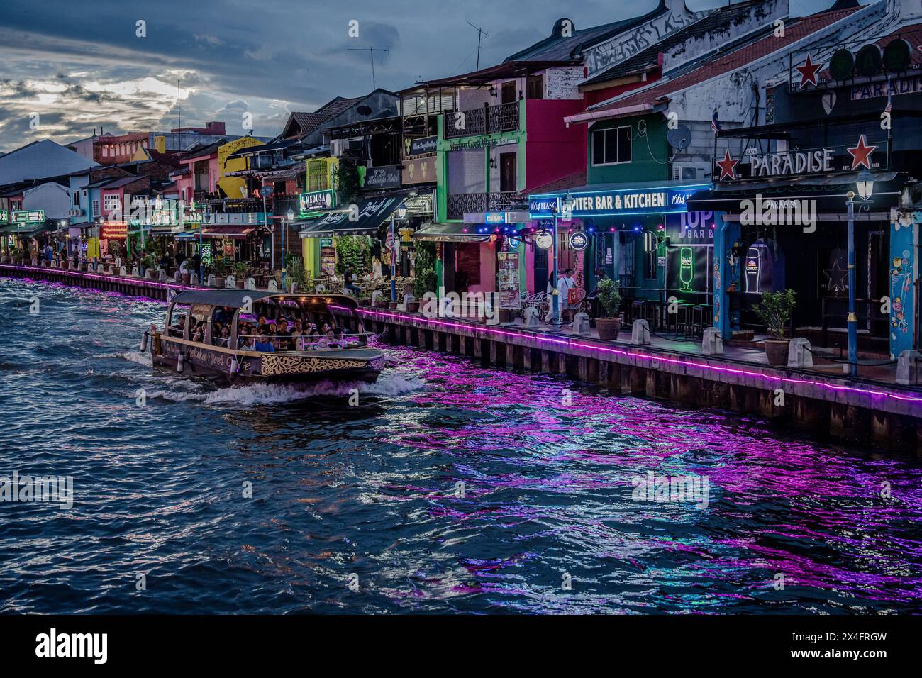 A lively scene along a river with colorful bars and restaurants ...
