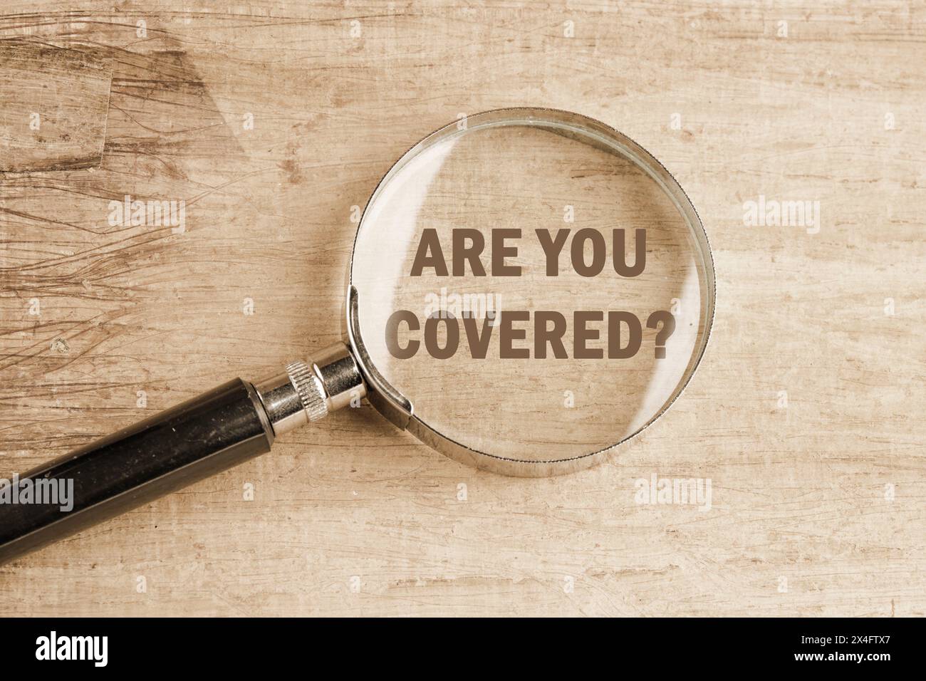 ARE YOU COVERED text written visible through a magnifying glass on an ...